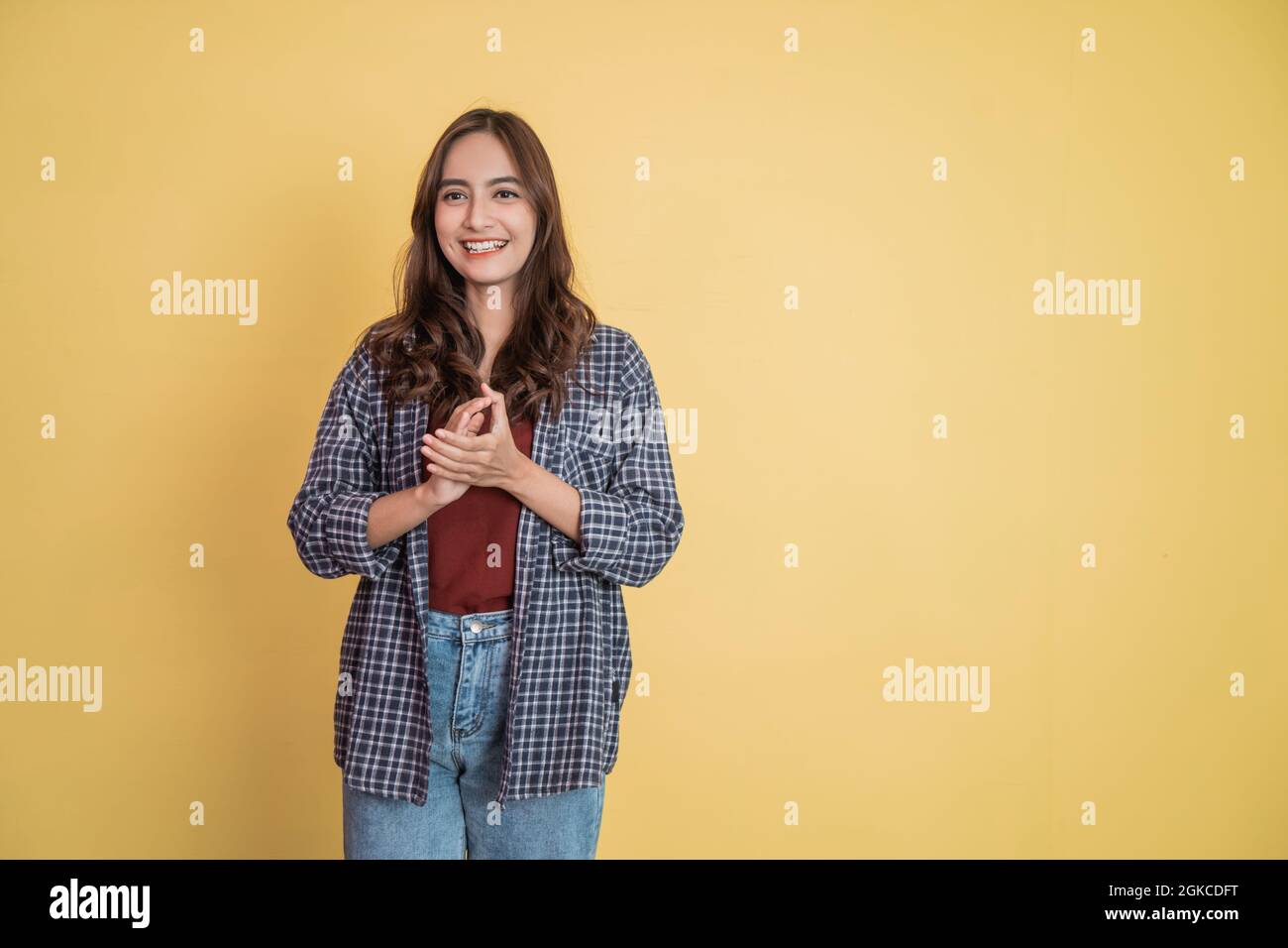 attractive woman smiling while clapping while looking at camera with ...