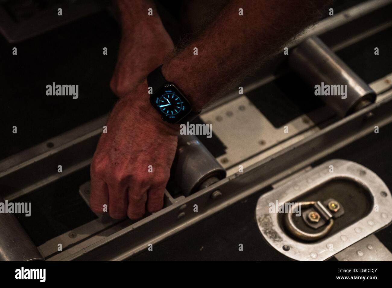 A U.S. Air Force loadmaster places rollers for cargo in a C-130 ...