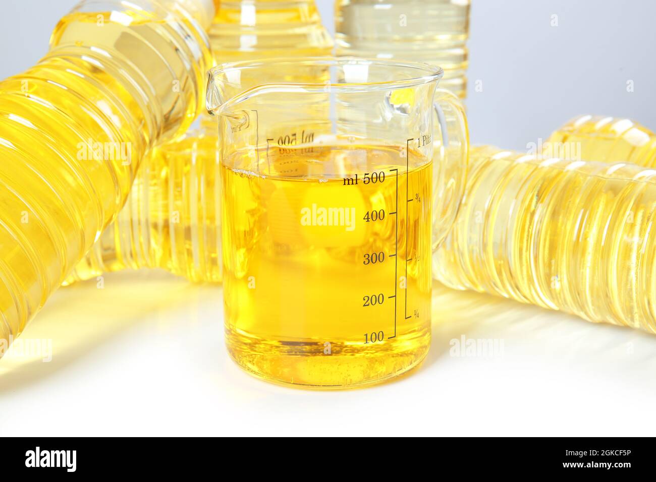 Beaker and bottles with cooking oil on white background Stock Photo - Alamy