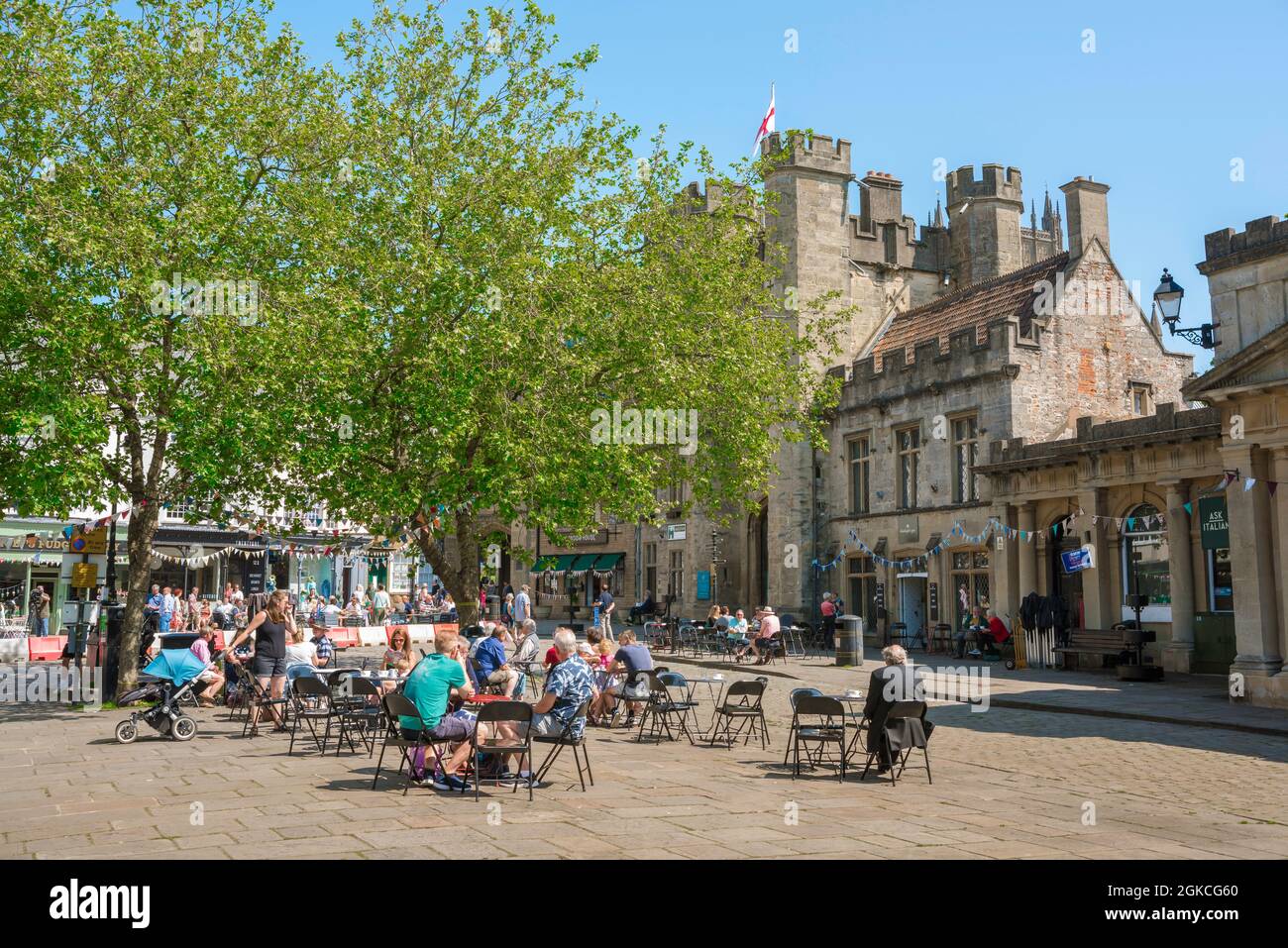 Wells UK, view in summer of people sitting at cafe tables in the ...