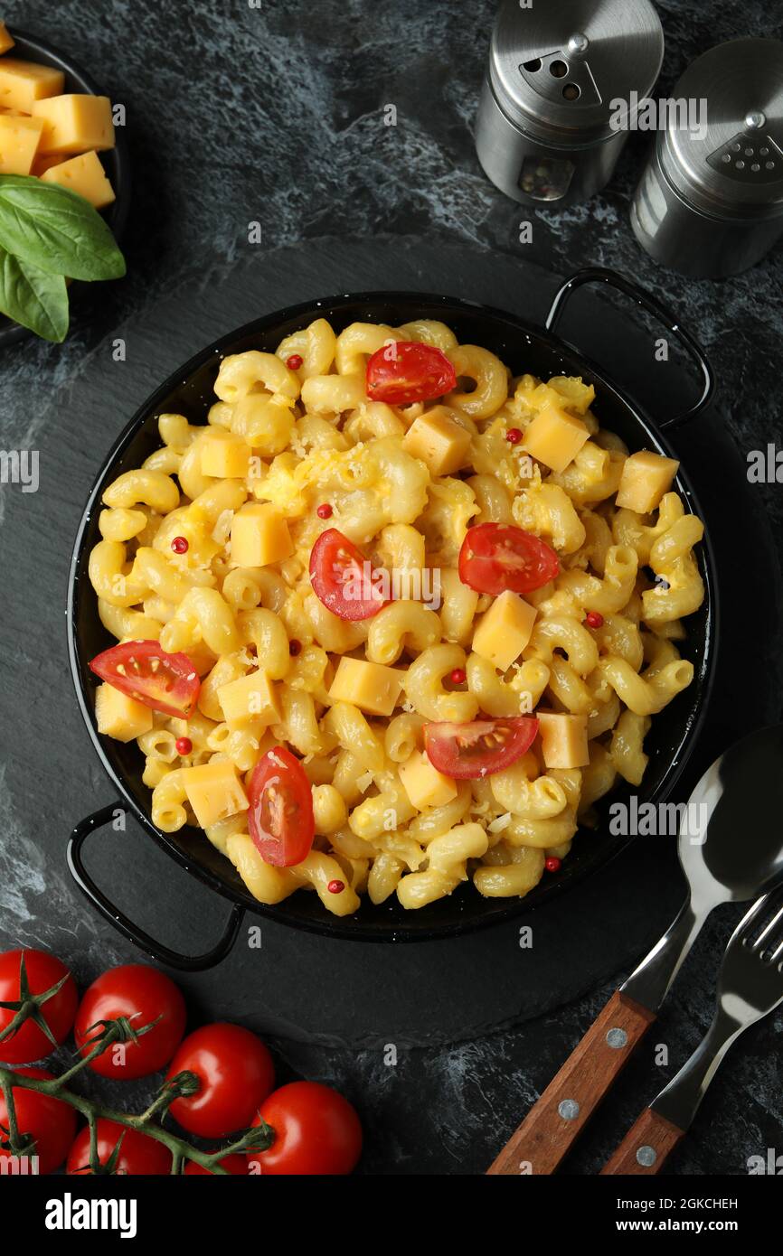 Concept of tasty eating with macaroni with cheese on black smokey table ...