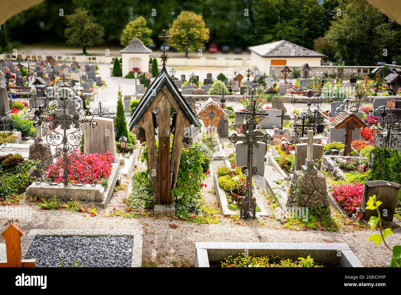 Peaceful Tombstone and graves in an ancient church graveyard. Beautiful flowers and trees in ...