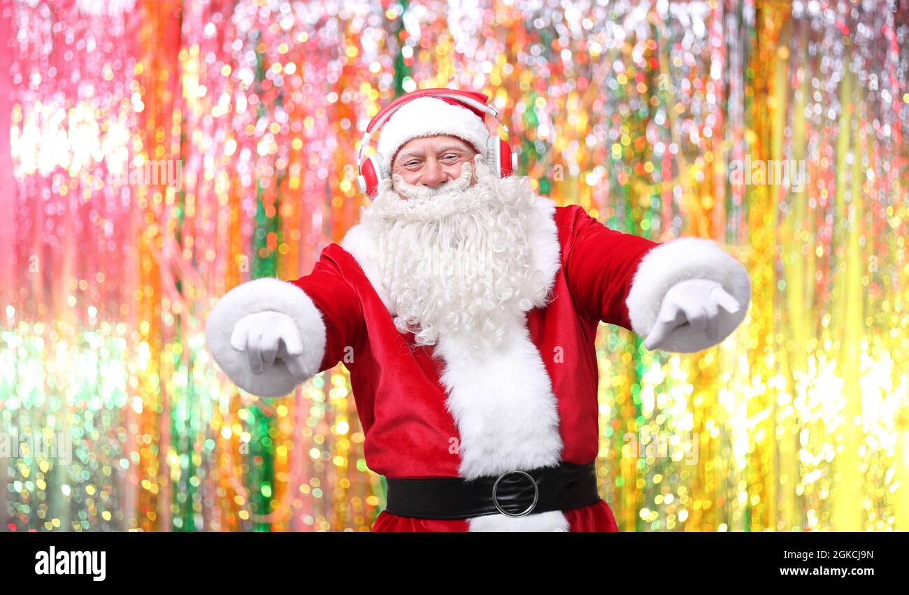 Santa Claus listening to music on color background Stock Photo - Alamy