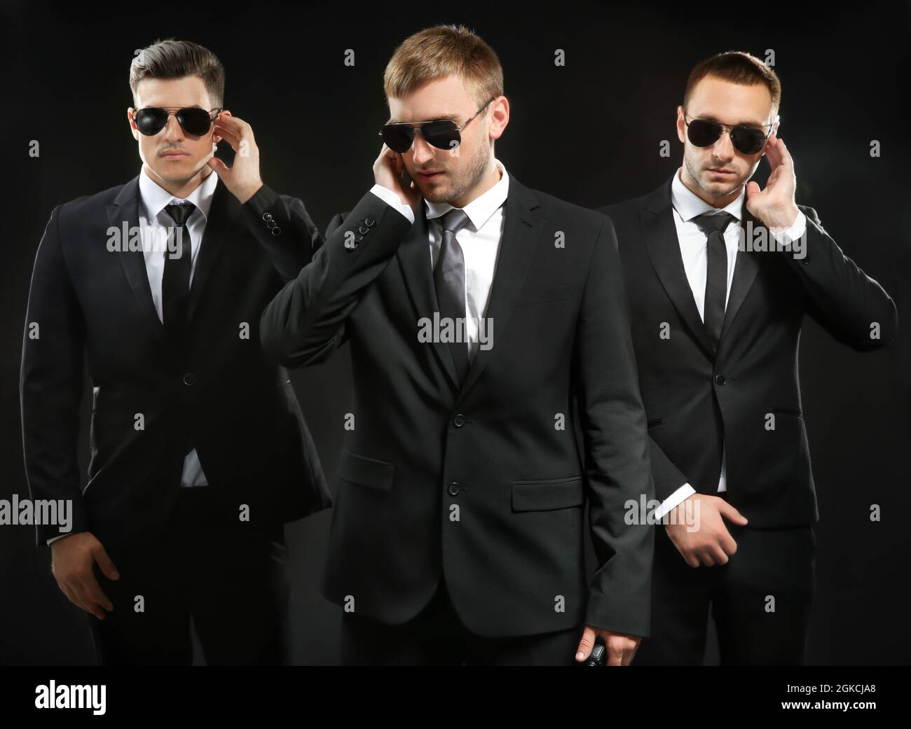 Handsome bodyguards on dark background Stock Photo - Alamy