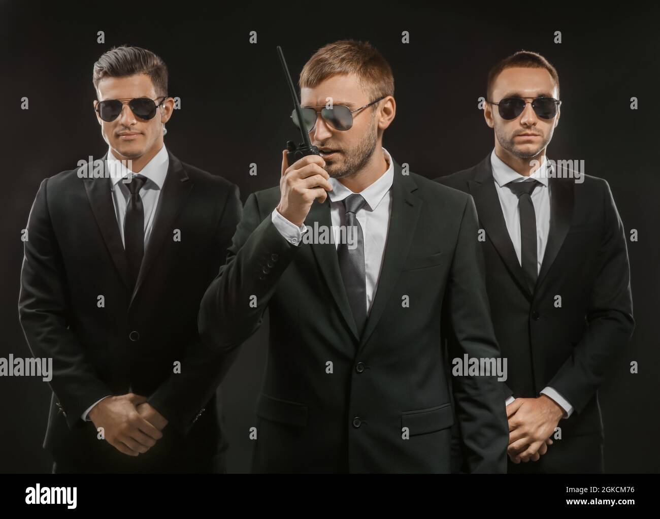 Handsome bodyguards on dark background Stock Photo - Alamy
