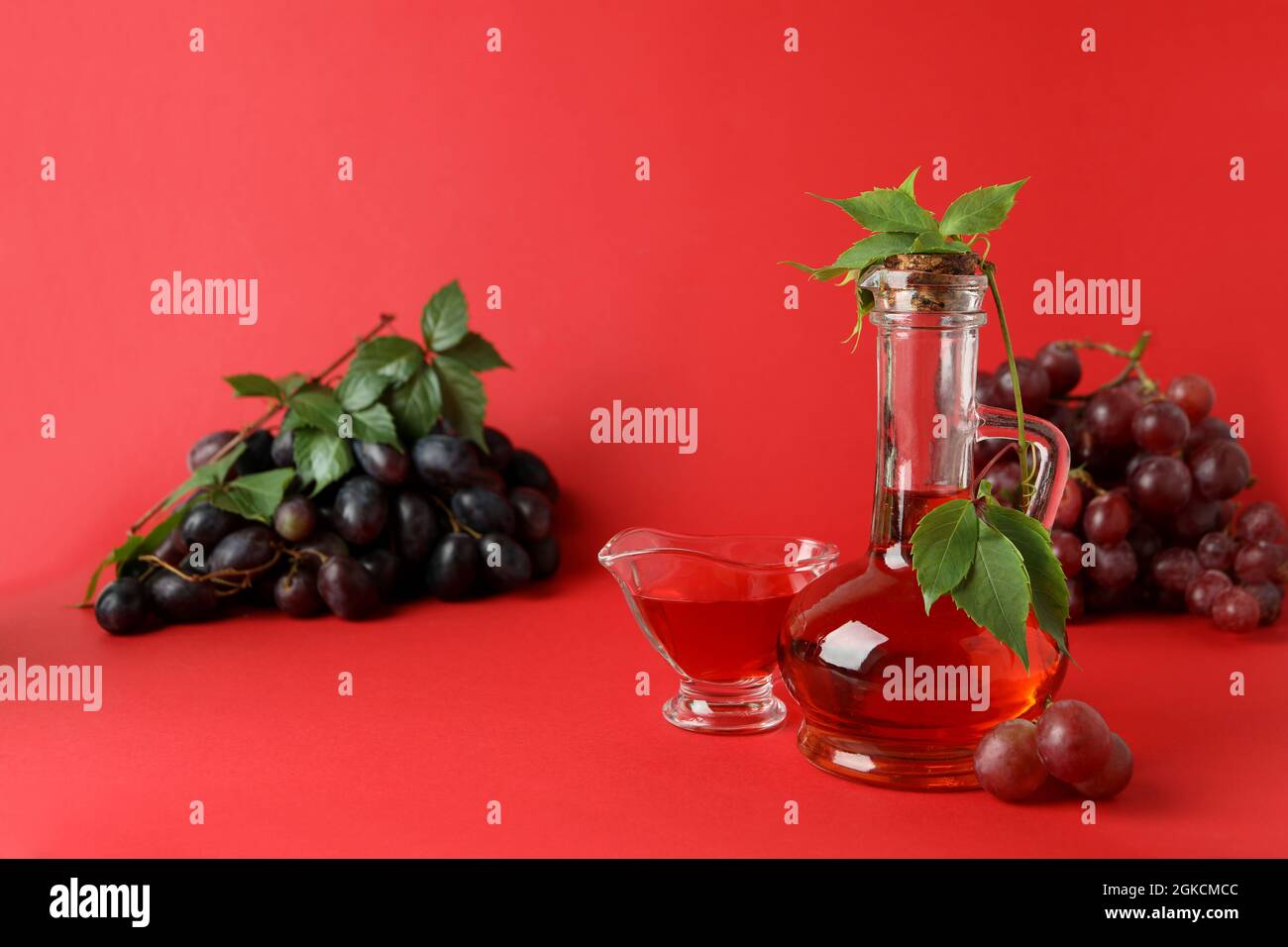 Concept of grape vinegar on red background Stock Photo - Alamy