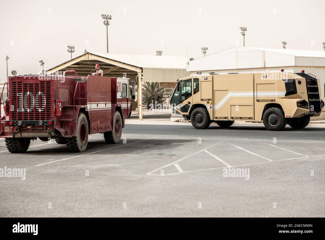 A P-19C firetruck drives past a red P-19 legacy truck at Al Udeid Air ...