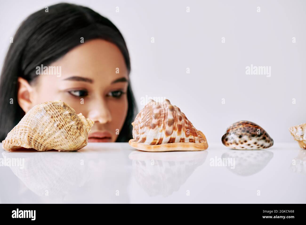 Beautiful african american woman looking on different seashells on ...
