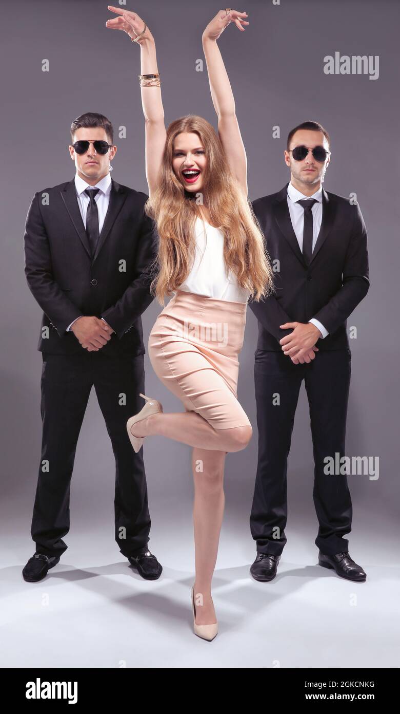 Famous celebrity with bodyguards on grey background Stock Photo - Alamy