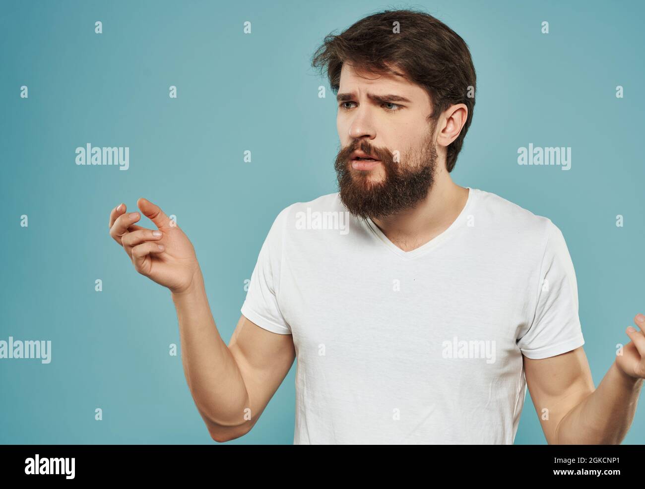 disgruntled man in white t-shirt anger scream emotion blue background ...