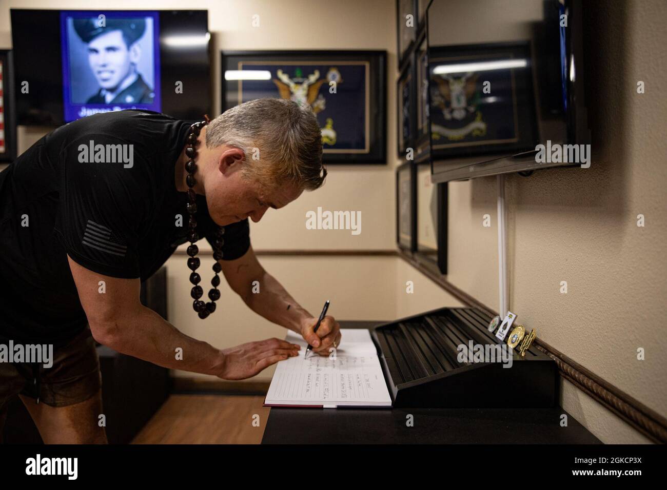 Ed Ray, a Gold Star Family Member, signs a memorial room guest book on ...
