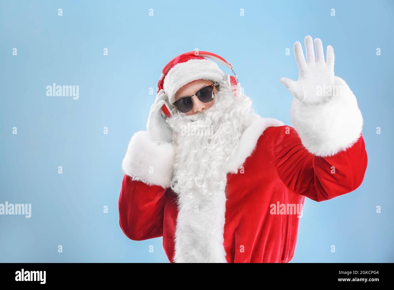 Santa Claus listening to music on color background Stock Photo - Alamy