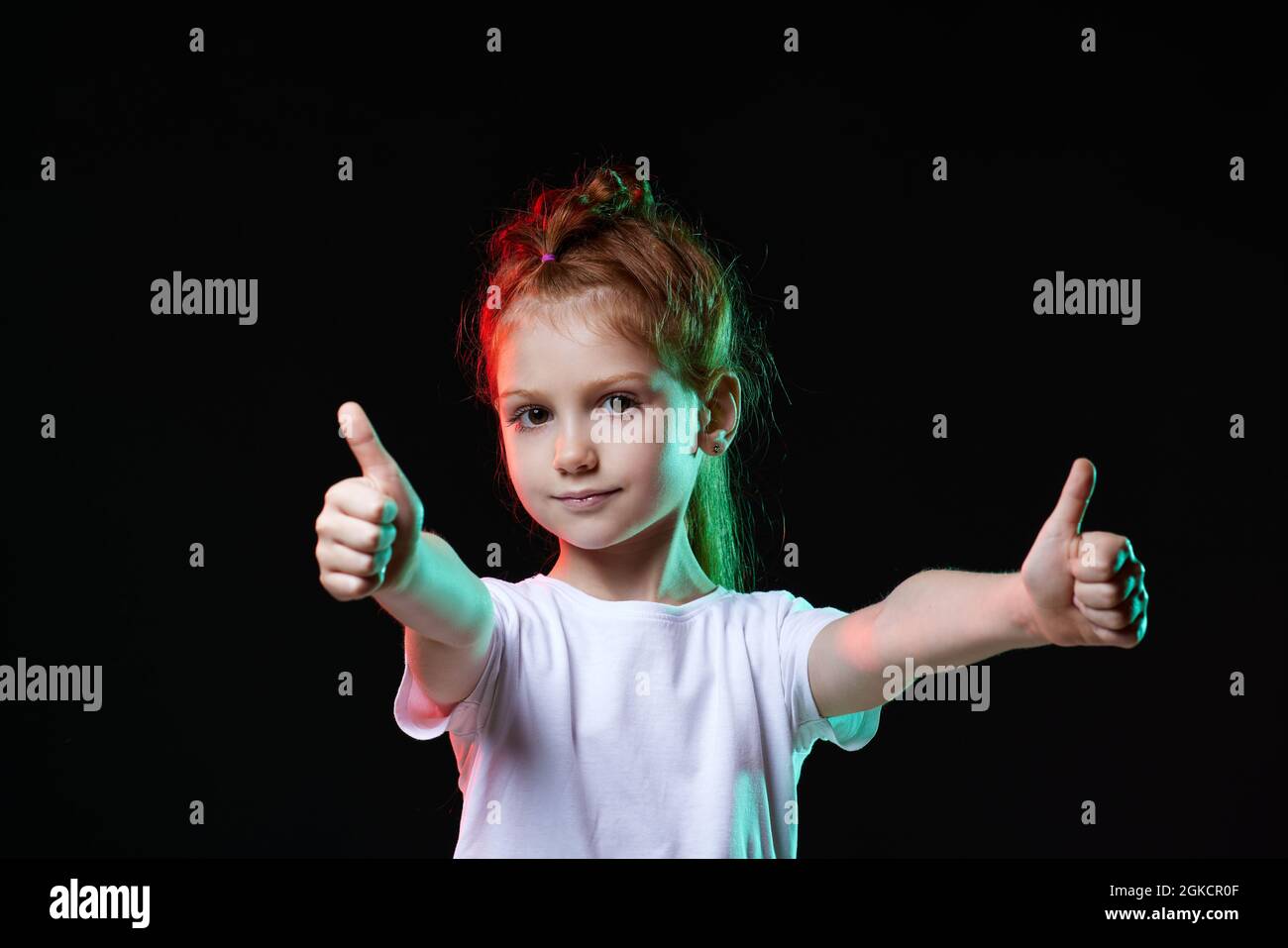 child girl showing Ok gesture on black background Stock Photo - Alamy