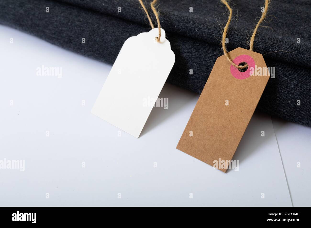Composition of gift tags with copy space and black fabric on white ...