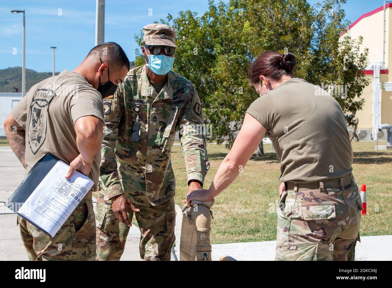 Sgt. 1st Class Kendell Richmond (center) instructs Spc. Jessie Weinman ...