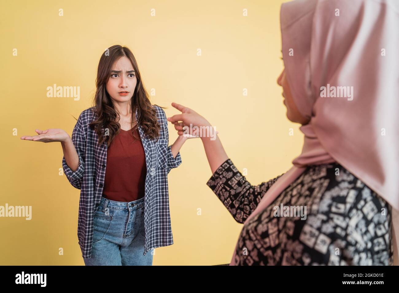 close up of an asian muslim woman in hijab pointing finger at woman ...