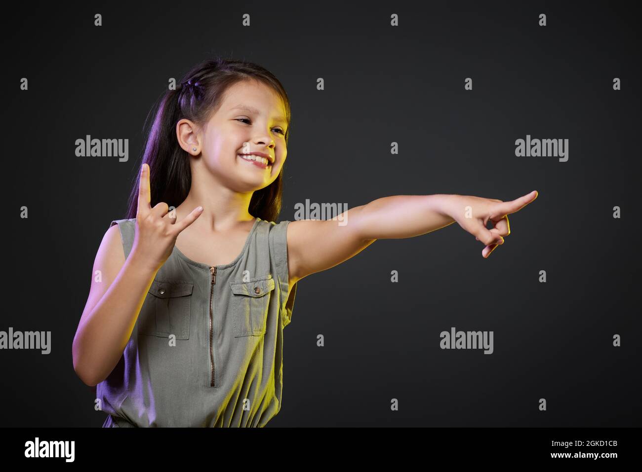 child girl pointing away on black background Stock Photo - Alamy
