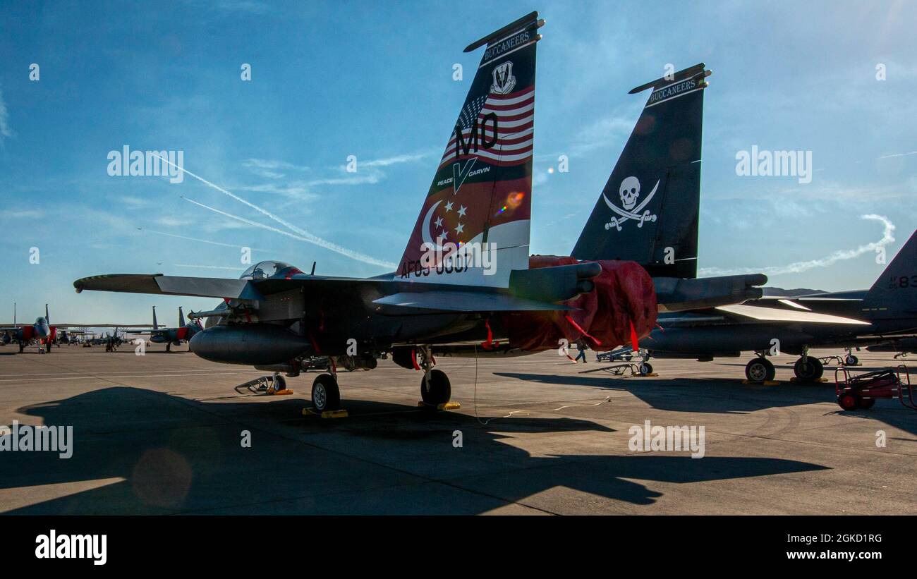 The U.S. Thunderbirds fly in the background of F-15SG Strike Eagles ...