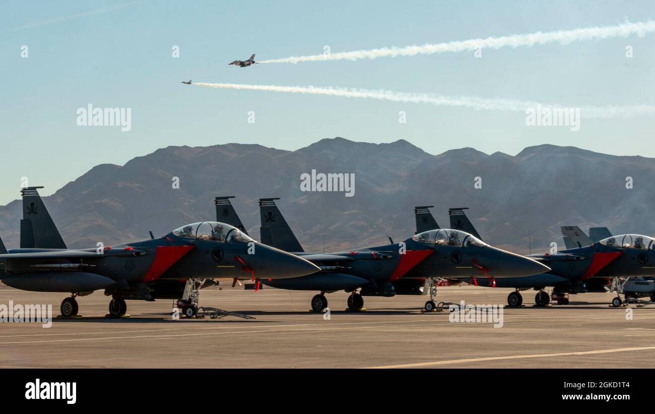 The U.S. Thunderbirds fly in the background of F-15SG Strike Eagles ...