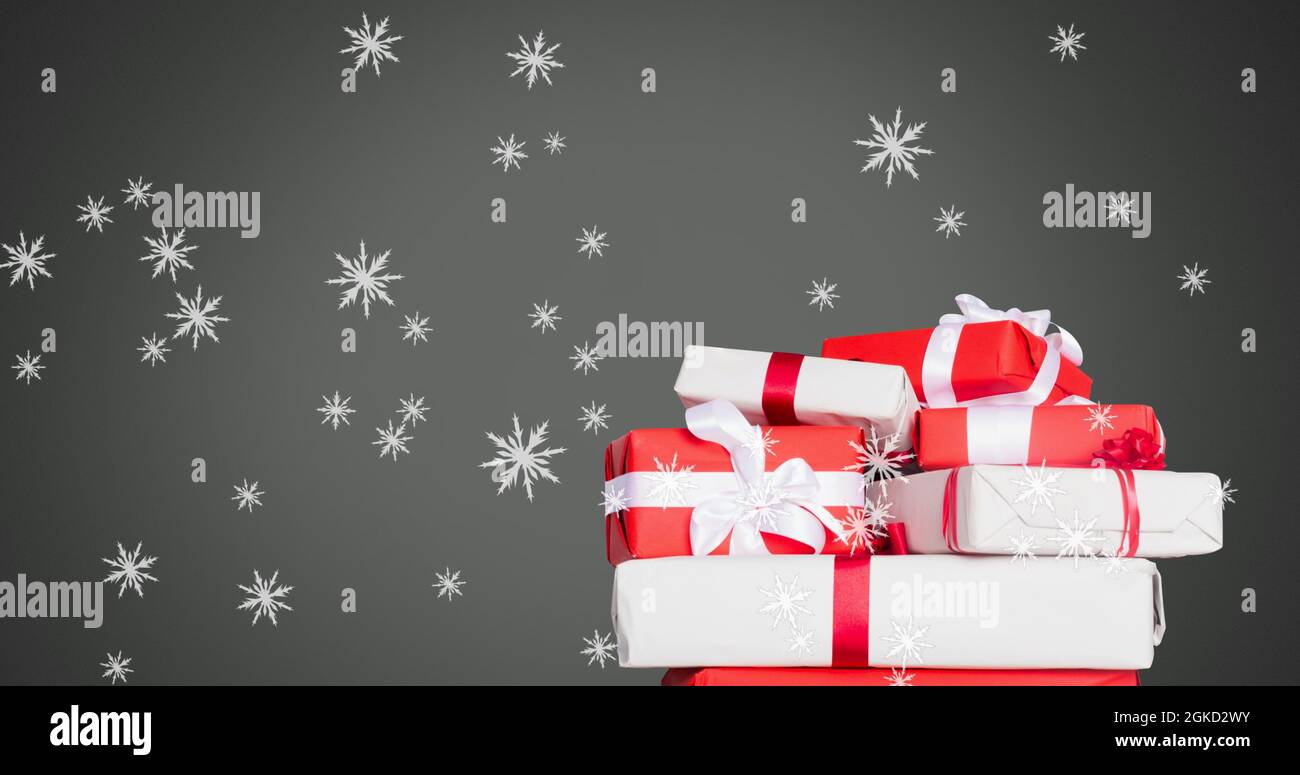 Digital image of snowflakes falling over christmas gifts against grey ...