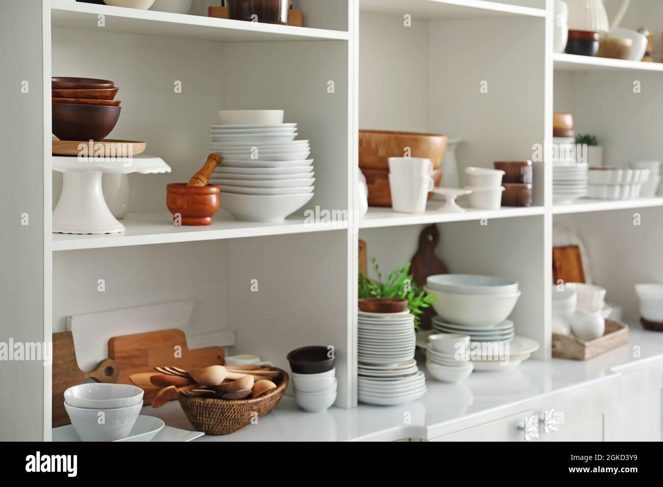 White storage stand with ceramic and wooden dishware in kitchen Stock ...