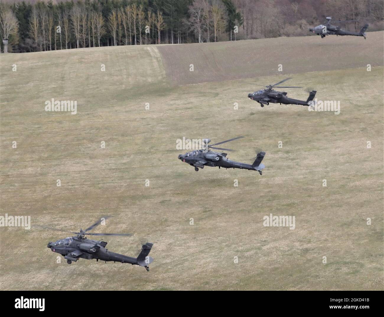 A line of Apache helicopters hover over ground during Operation Eminent ...