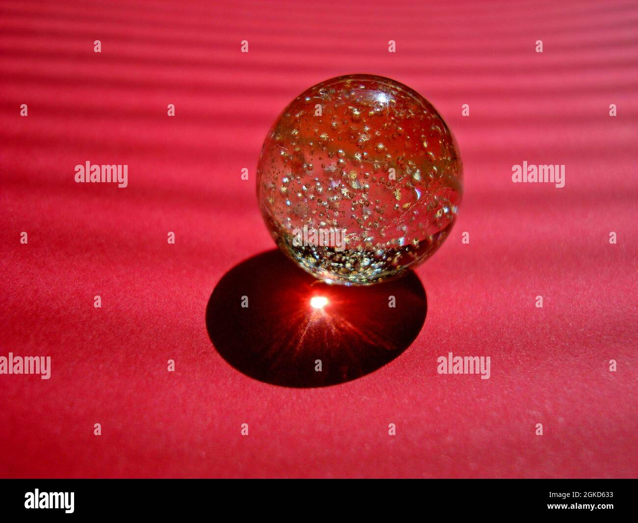 Marble ball on red background Stock Photo - Alamy