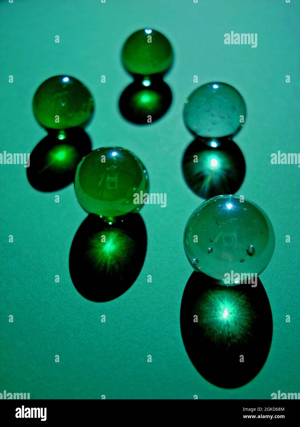 Marbles balls on green background Stock Photo - Alamy