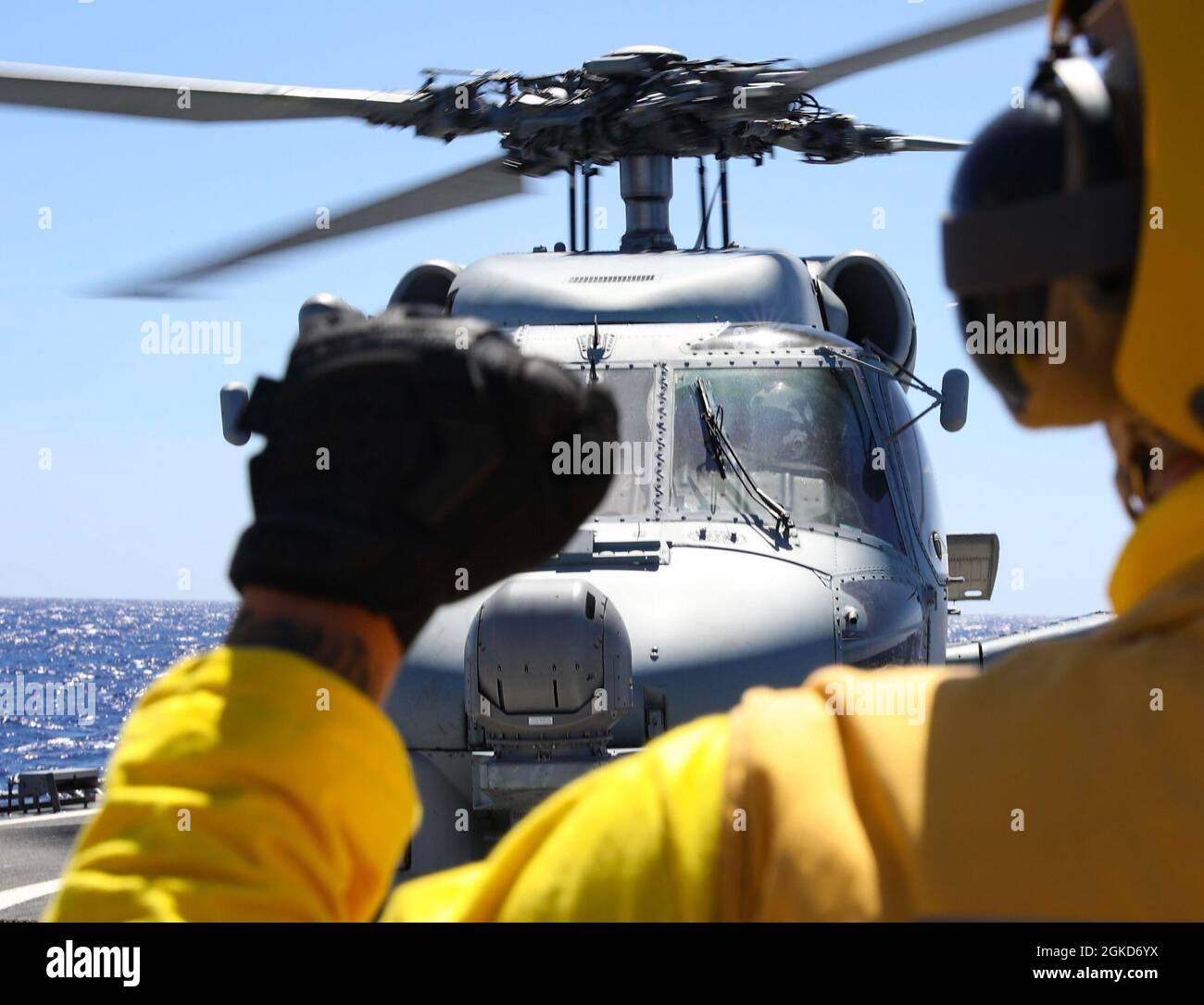 Boatswain’s Mate Seaman Jason Farris, from Sparta, Tenn., signals to an ...
