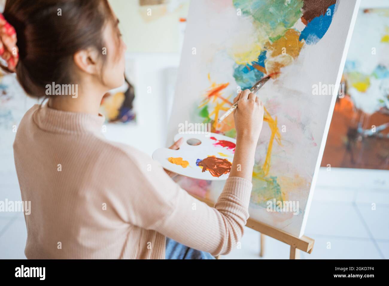 painter artist painting on canvas shoot from her back Stock Photo - Alamy