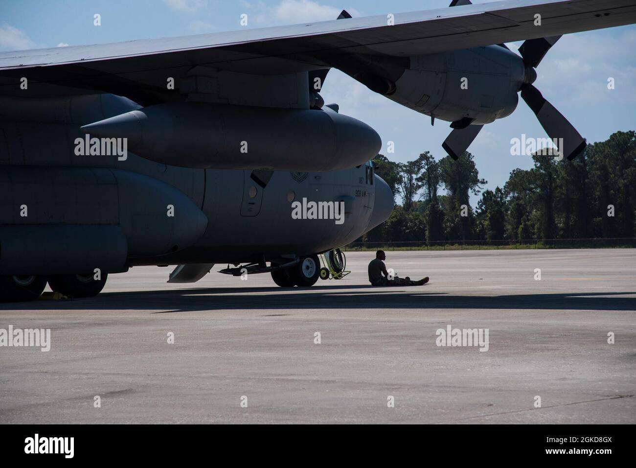 An Airman finds shade under a C-130H Hercules assigned to the 357th ...