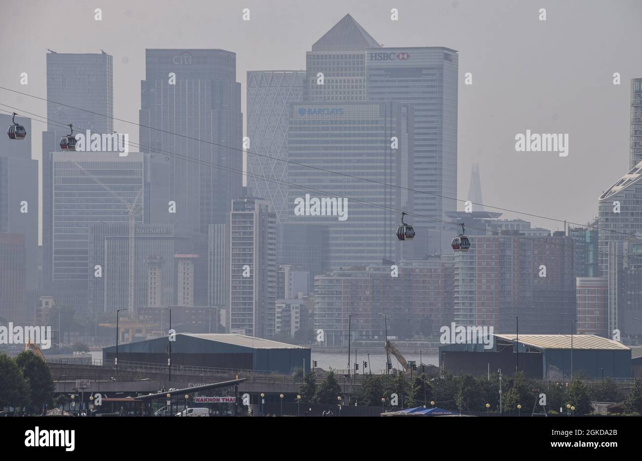 Canary Wharf and Emirates Air Line cable cars on a hazy day. London ...