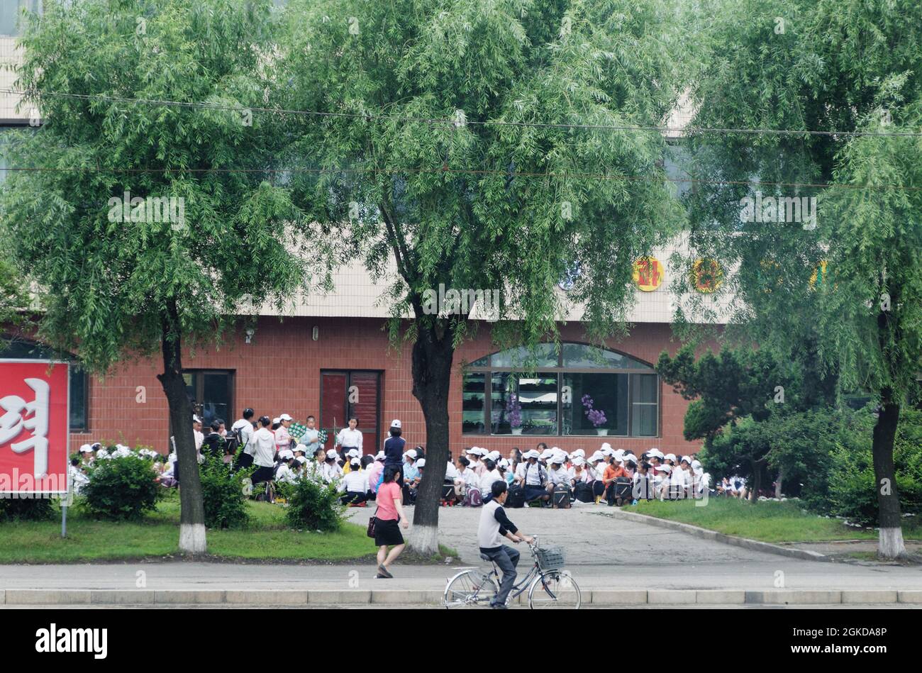 School children sitting outside a school in a crowd, Pyongyang, North ...