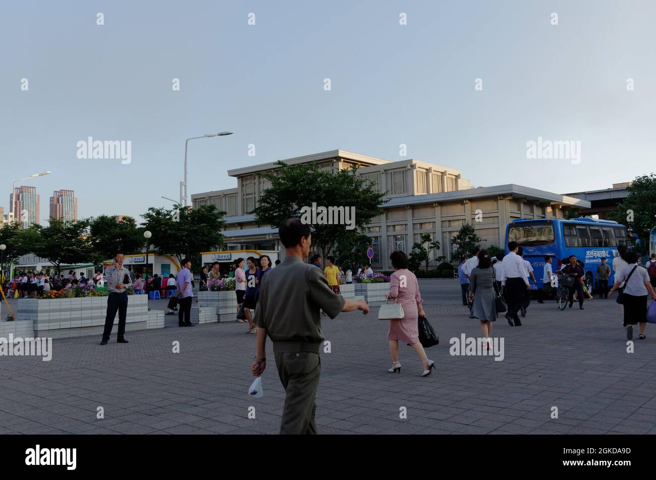 Tour buses picking up tourists among the crowd and workers at Pyongyang ...