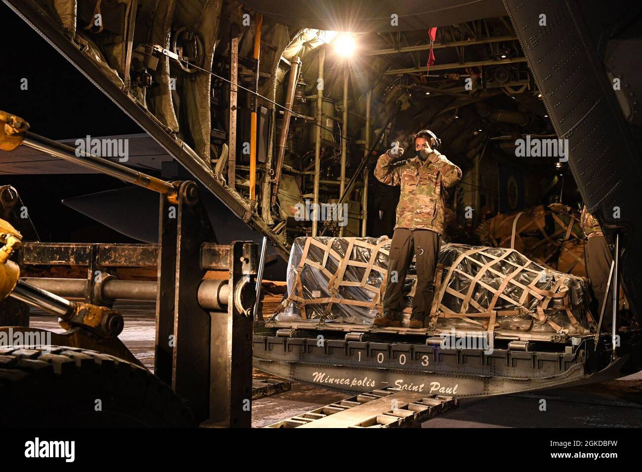 A U.S. Air Force loadmaster, directs a forklift into place in order to ...