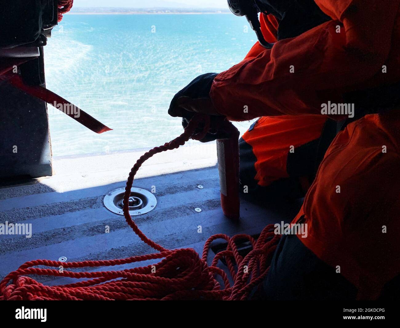 A Coast Guard Sector San Diego air crewmember prepares to drop a line ...