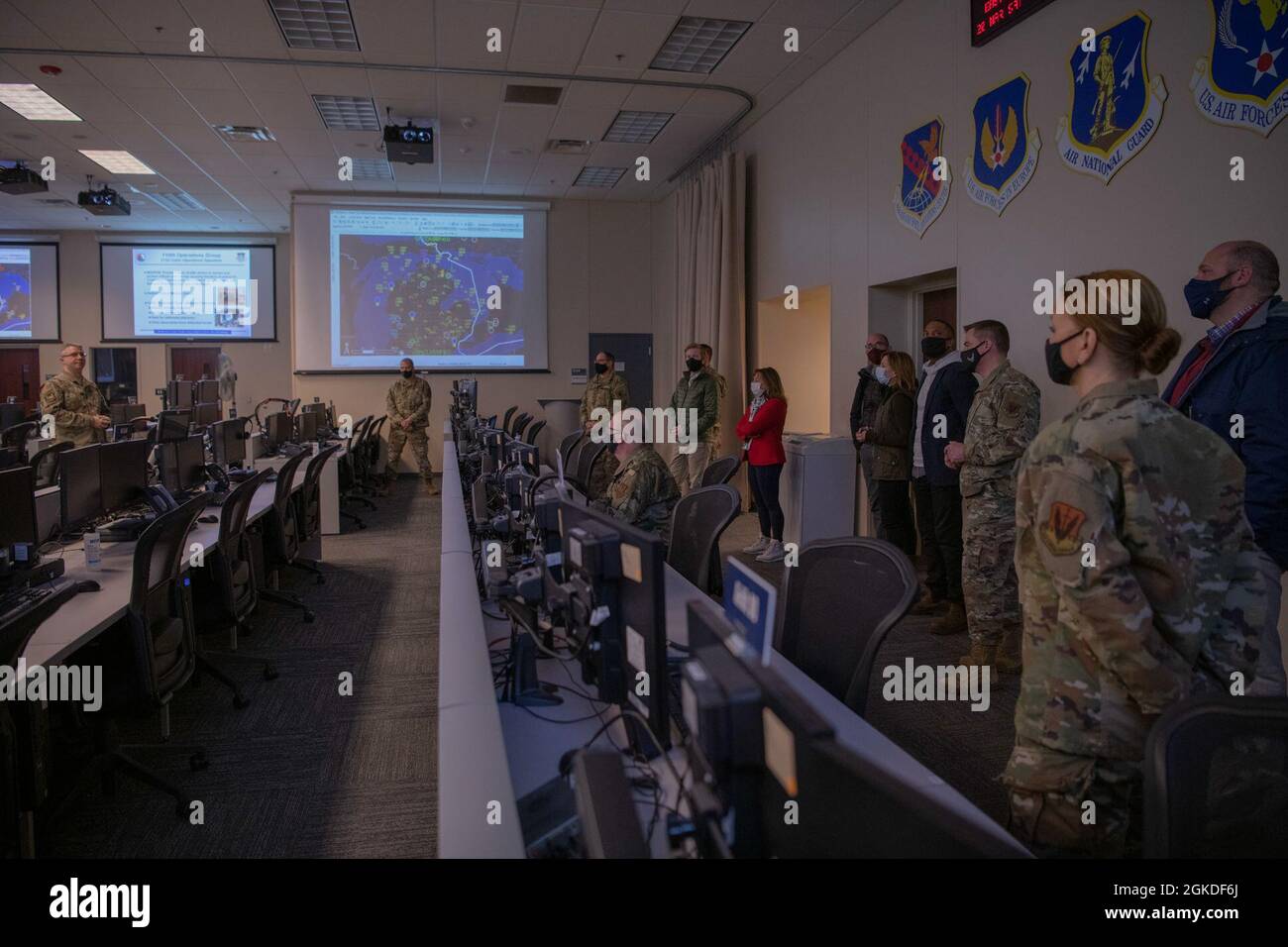 Distinguished visitors listen intently to a brief given on the Air ...