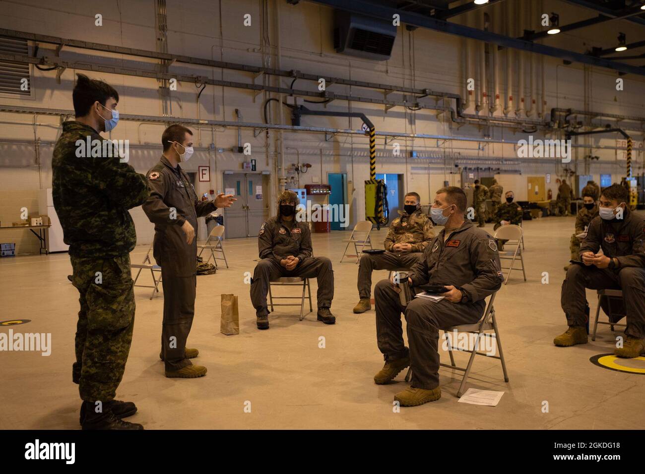 A Canadian pilot of the RCAF is briefing USAF pilots on the floor of ...