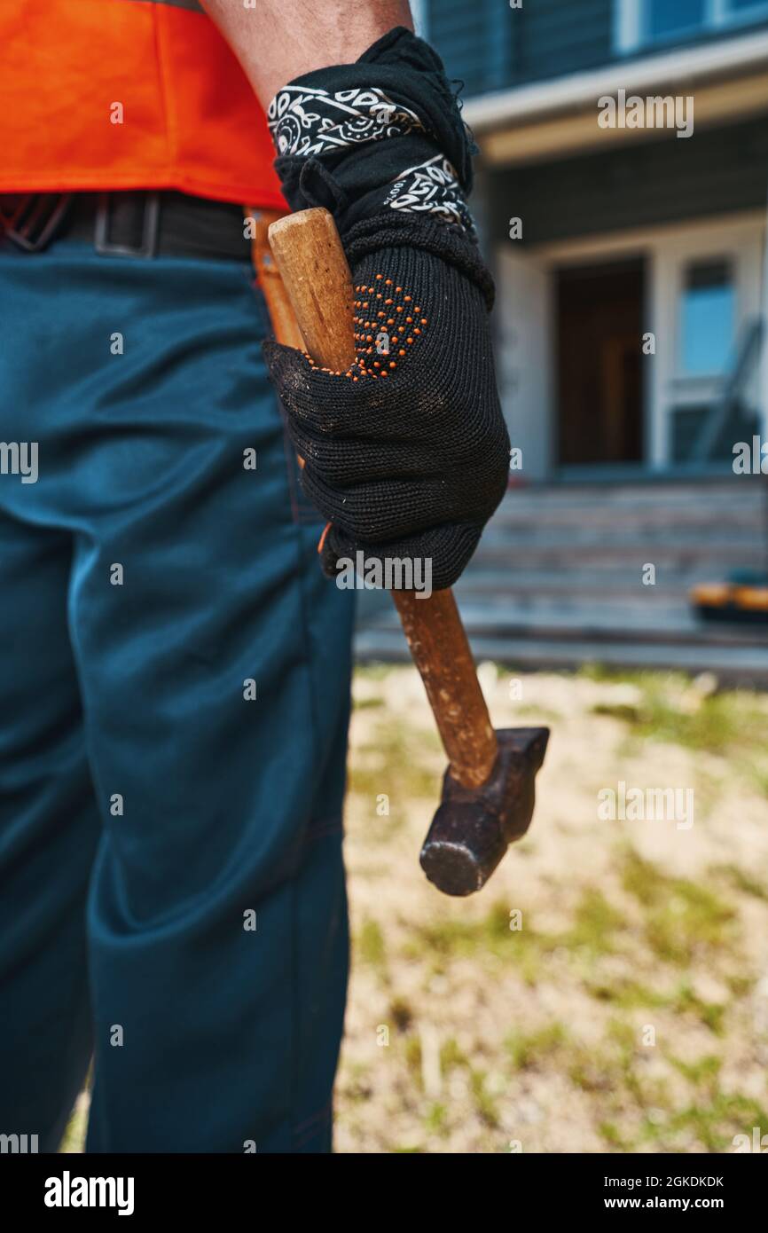 Person holding hammer while looking at house Stock Photo - Alamy