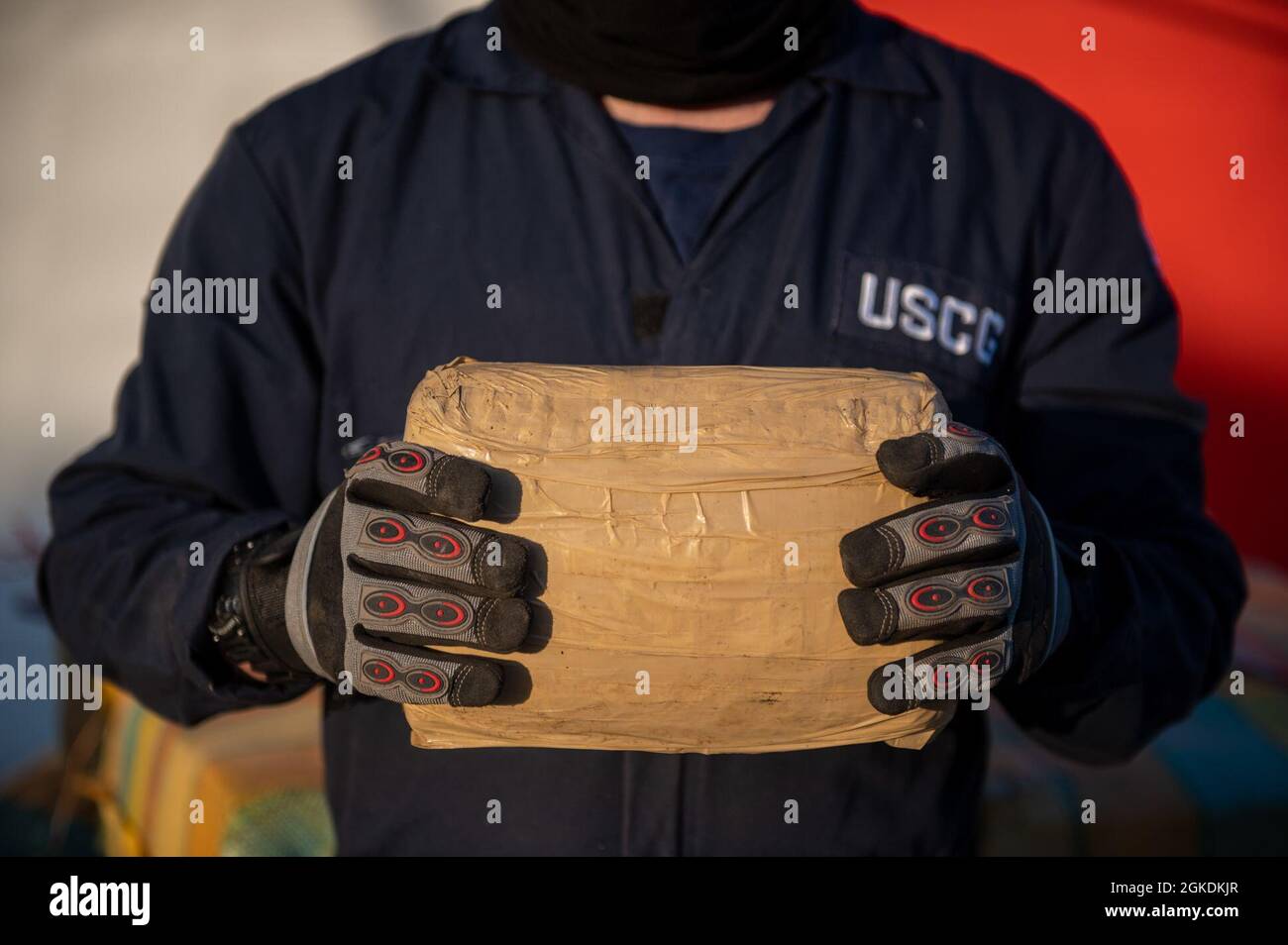A crew member from the Coast Guard Cutter Munro holds seized contraband ...