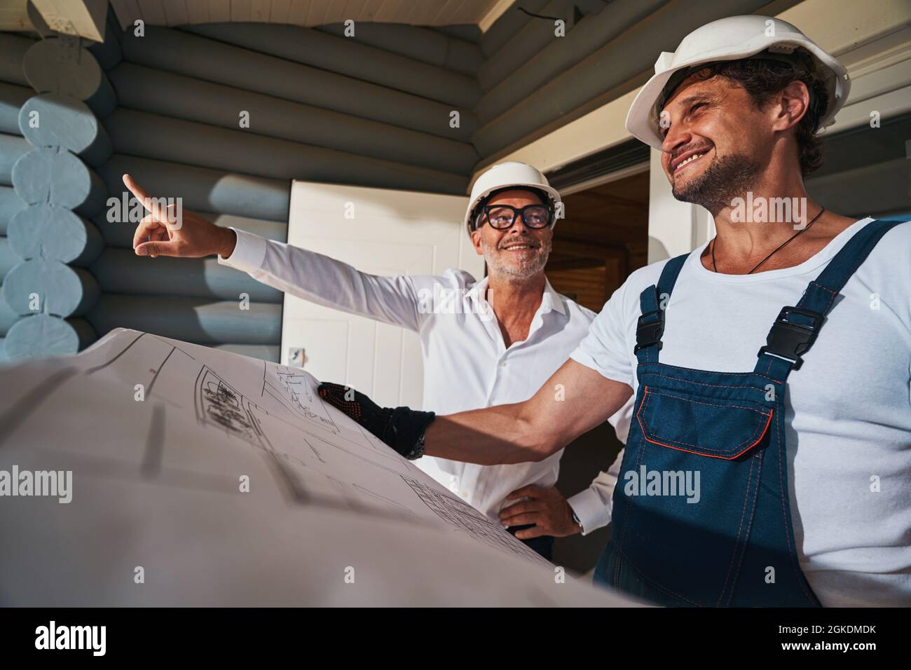 Smiling builders estimating the amount of work with layout Stock Photo ...