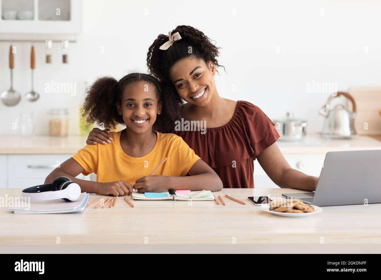 Loving black mother helping her daughter with homework Stock Photo - Alamy