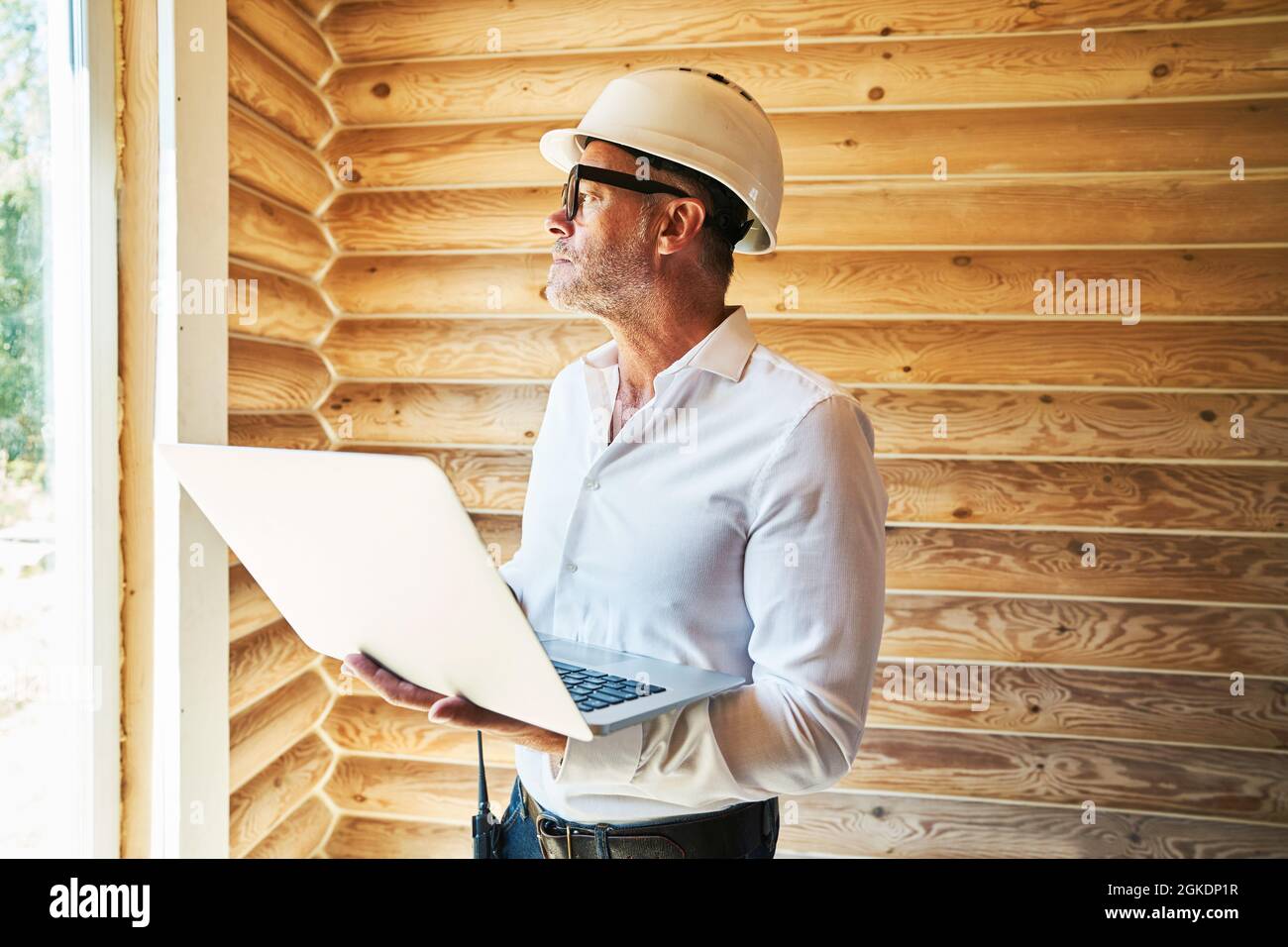 Civil engineer in safety cap working with laptop in building Stock ...