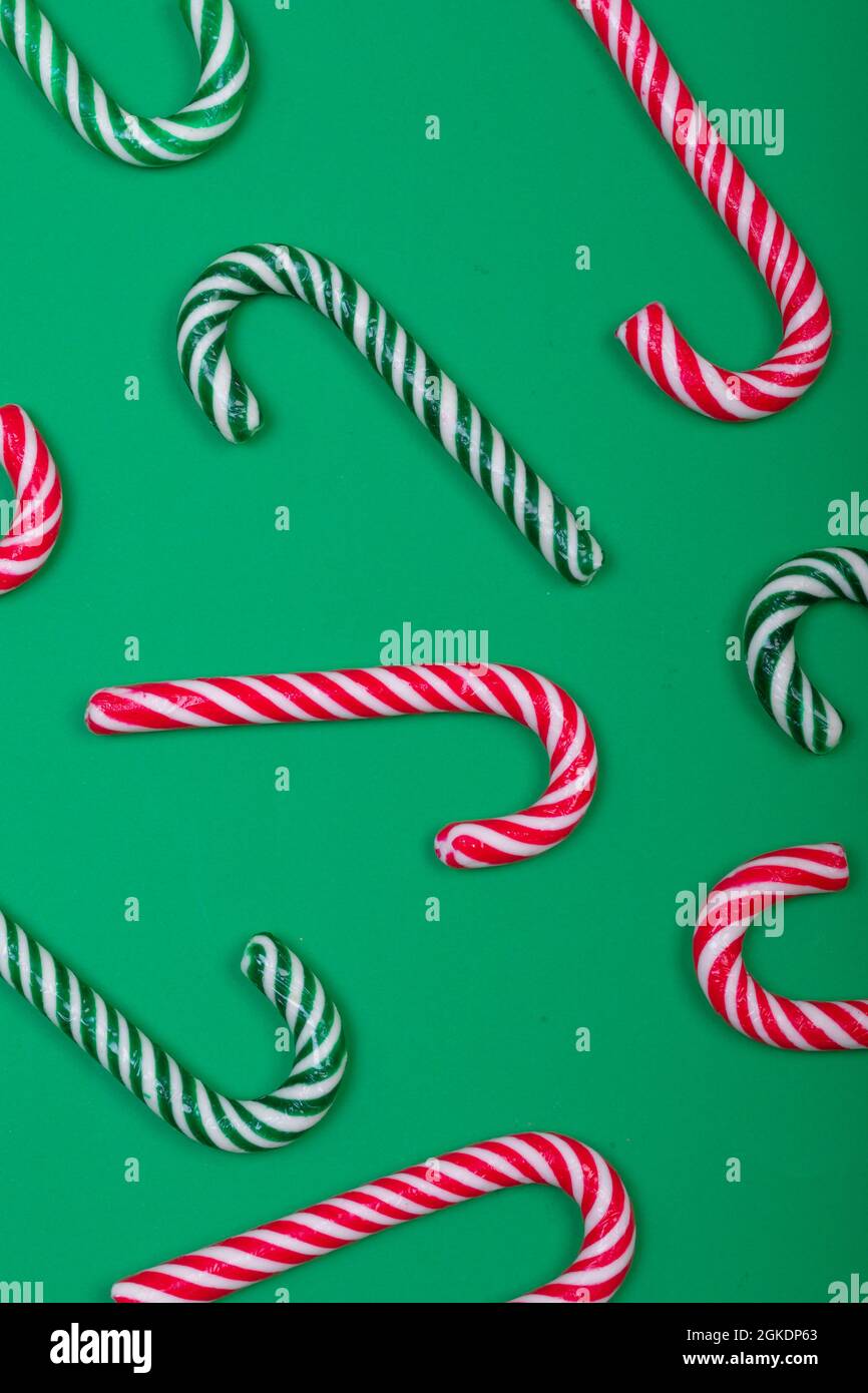 Composition of multiple green and red candy canes on green background ...