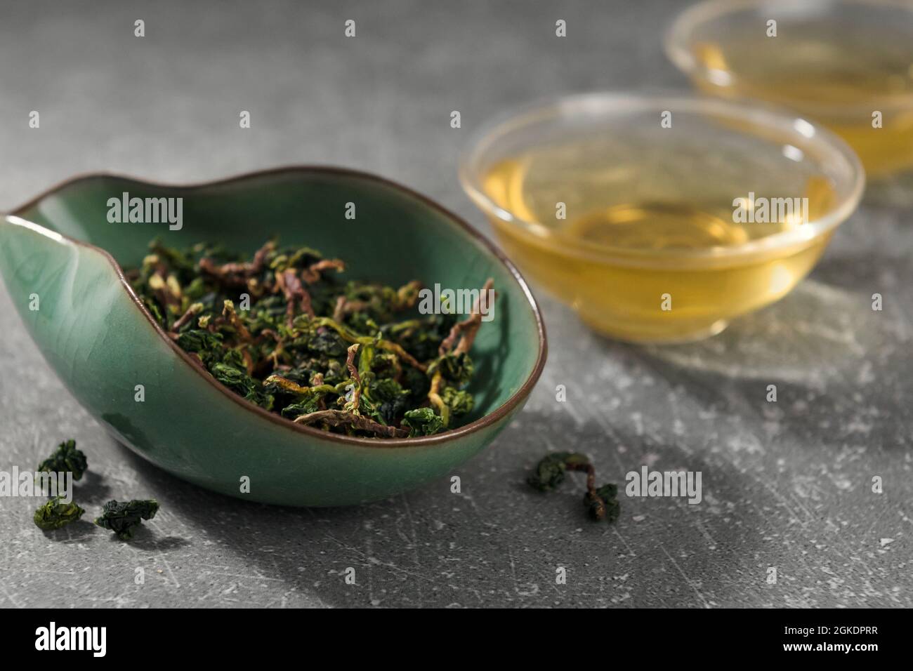 Dry tea leaves and hot drink in asian style cups. Oolong chinese tea in ...