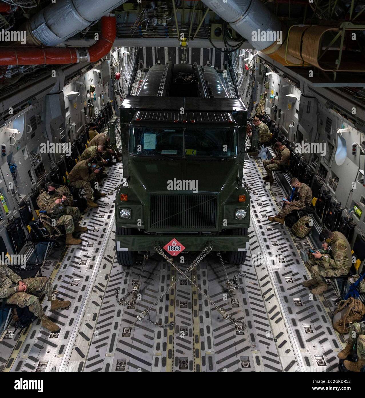 A fuel truck and passengers fly on a Dover Air Force Base C-17 ...
