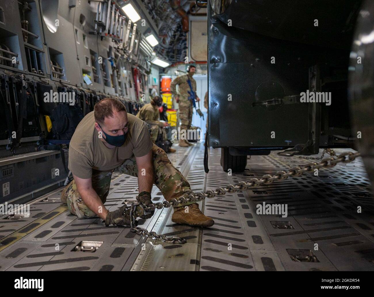Senior Airman Eric Jones, 3rd Airlift Squadron loadmaster, chains a ...