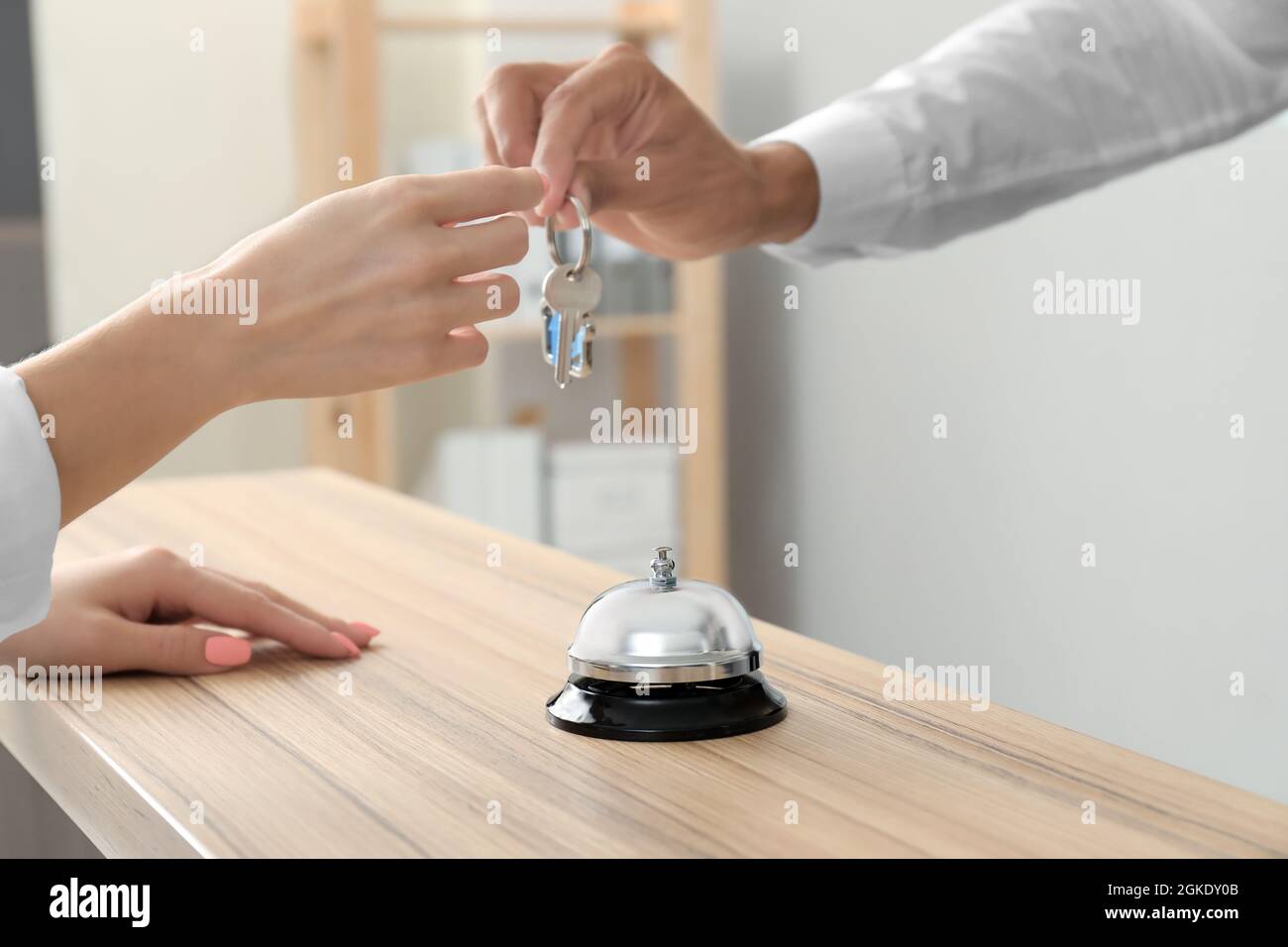 Male receptionist giving key from hotel room to client Stock Photo - Alamy