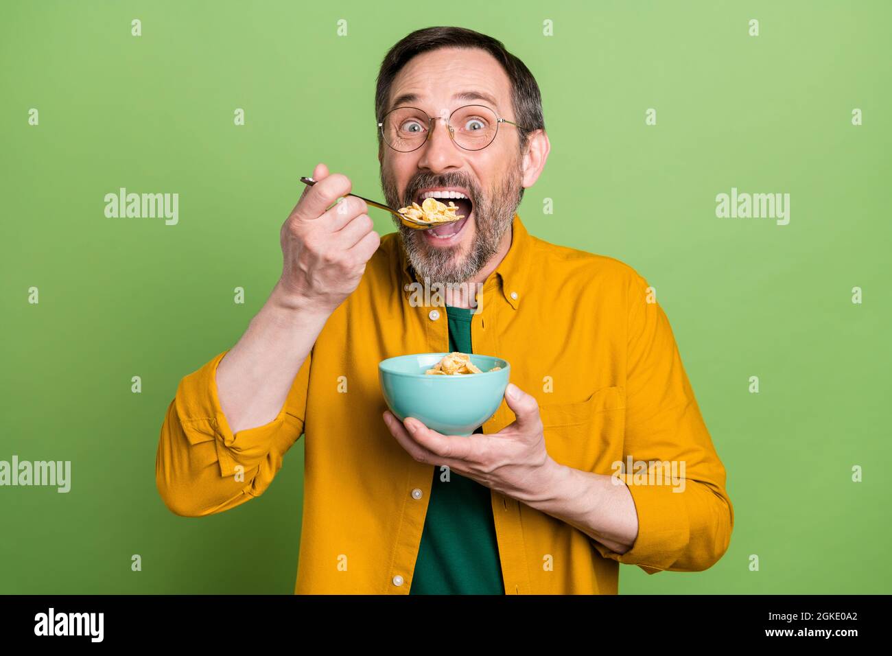 Photo of mature man happy positive smile eat cornflakes lunch tasty ...