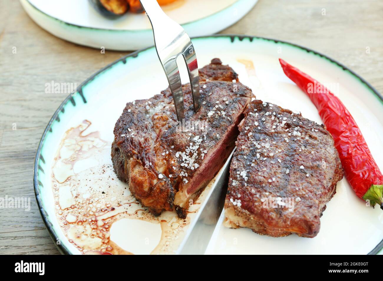 Cutting rare steak on plate Stock Photo - Alamy